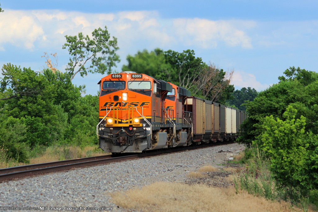 BNSF 6395 leads this empty coal out of storm clouds.